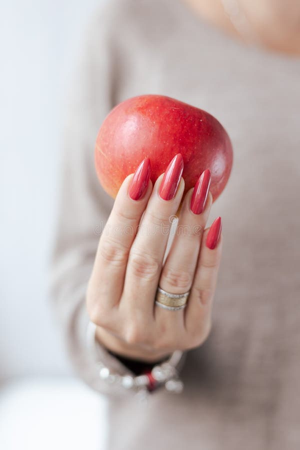 Female Hands with Red Nails are Holding a Ripe Red Apple Fruit. Stock ...