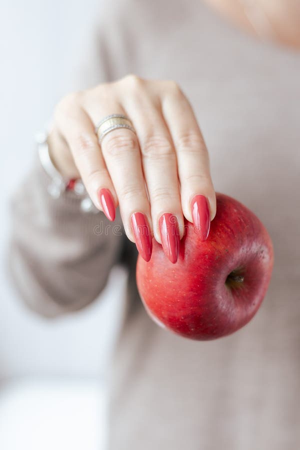 Female Hands with Red Nails are Holding a Ripe Red Apple Fruit. Stock ...
