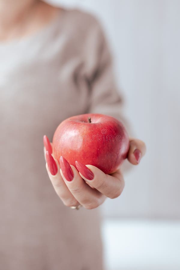 Female Hands with Red Nails are Holding a Ripe Red Apple Fruit. Stock ...