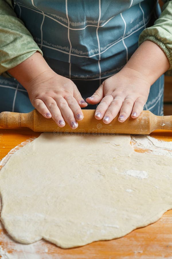 Female Hands Roll Out Dough on the Table with a Rolling Pin. Vertical ...