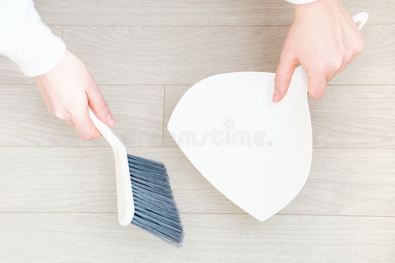 Female Hands Sweeping the Floor with a Brush and Dustpan Top View Close ...