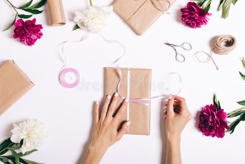 Female Hands Tie a Ribbon on a Gift for a Holiday on a White Tab Stock ...