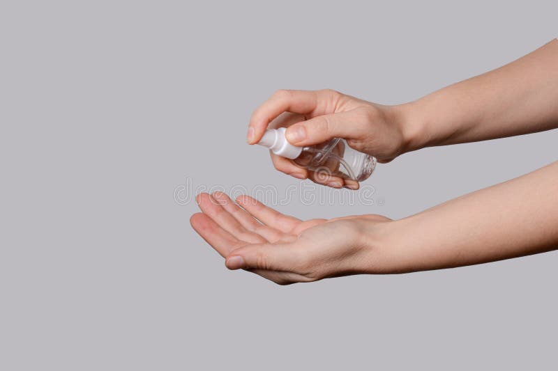 Female Hands Using Hand Sanitizer Spray Dispenser Over Light Grey ...
