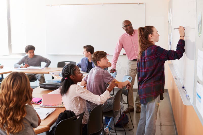 Female High School Pupil Writing on Whiteboard in Class Stock Photo ...