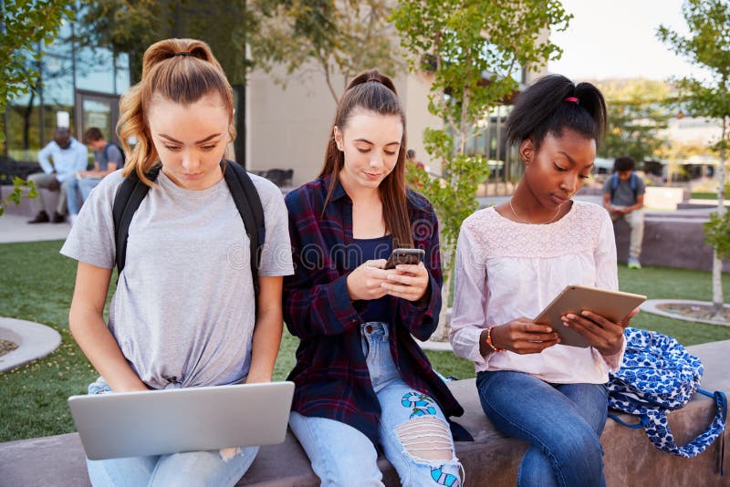 Female High School Students Using Digital Devices Outdoors during ...