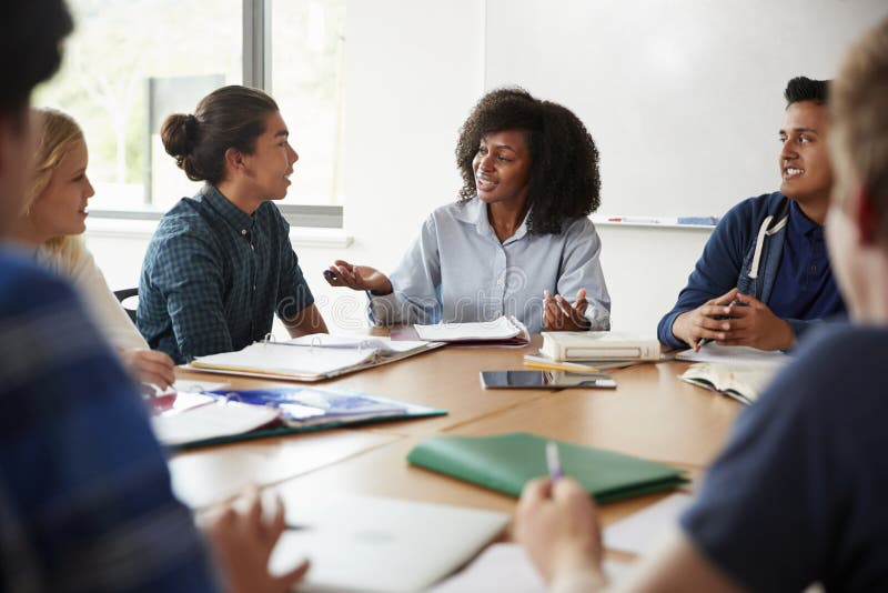 Female High School Tutor Sitting at Table with Pupils Teaching Maths ...