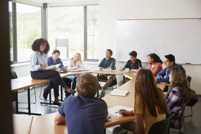 Female High School Tutor Sitting at Table with Pupils Teaching Maths ...