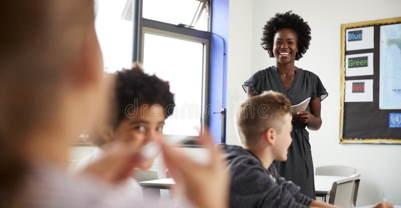 Female High School Tutor Standing by Table with Students Teaching ...