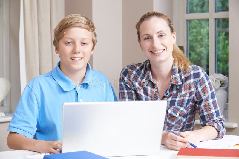 Female Home Tutor Helping Boy with Studies Using Laptop Stock Photo ...