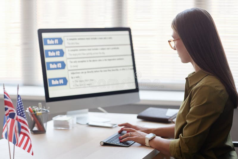 Female Instructor Typing on Computer Creating Lesson for Students in ...