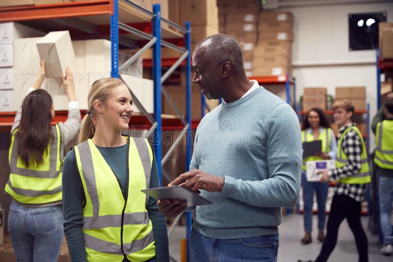 Female Intern with Team Leader Looking at Digital Tablet Inside Busy ...