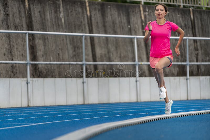 Female Jogger on a Blue Track Stock Image - Image of sporty, sprint ...