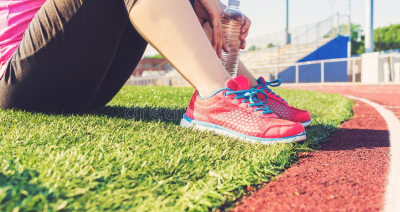 Female Jogger Sitting on the Side of a Stadium Track Stock Image ...
