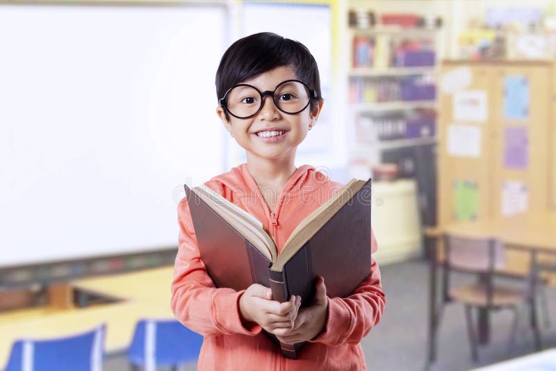 Female Kindergarten Student Reads Book in Class Stock Image - Image of ...