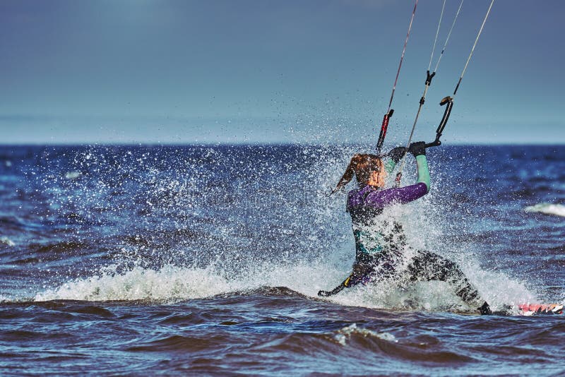 A Female Kiter Slides on the Surface of the Water. Stock Photo - Image ...