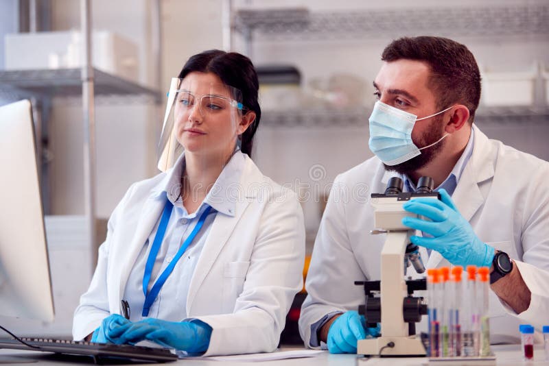 Female Lab Worker Wearing White Coat Recording Blood Test Results on ...