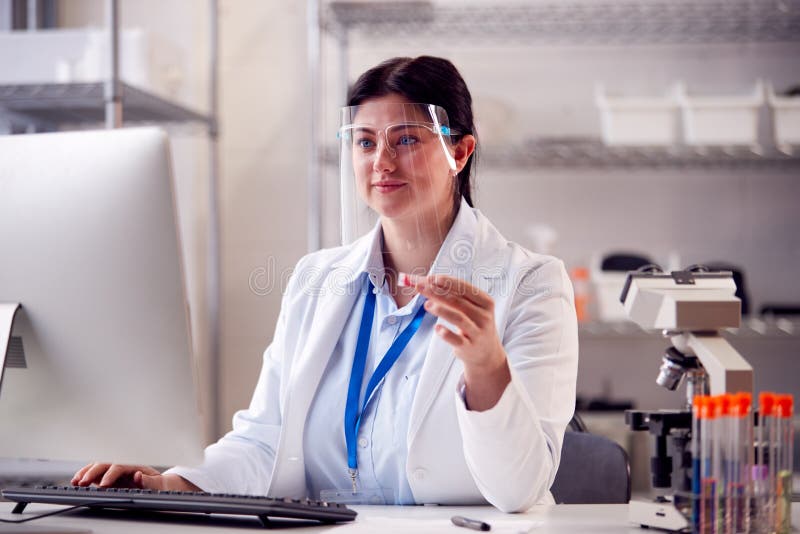 Female Lab Worker Wearing White Coat Recording Test Results on Computer ...