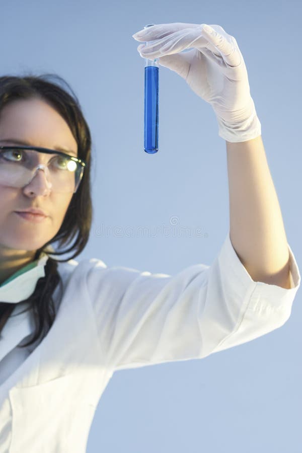 Female Laboratory Assistant Holding One Flask in Hand during Scientific ...