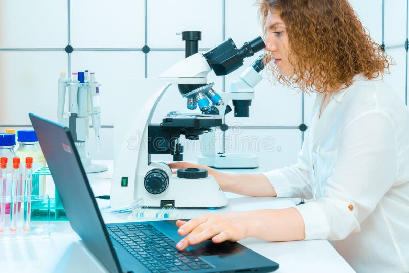 Female Laboratory Assistant in a Science Laboratory with a Microscope ...