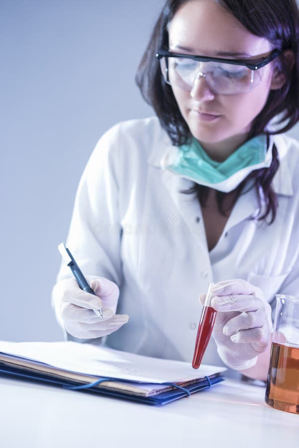 Female Laboratory Worker Dealing with Flask Containing Liquid Chemicals ...