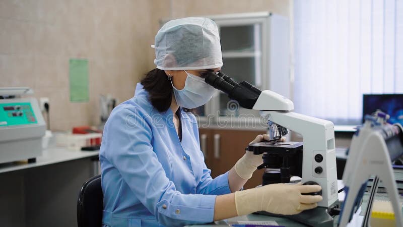 Female Laboratory Worker Using Microscope. Young Female Specialist in ...