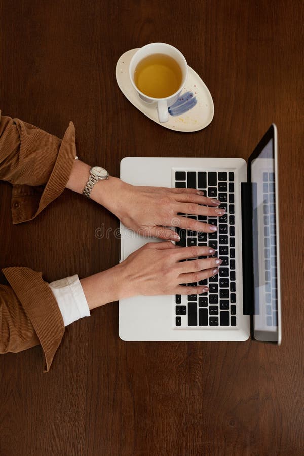 Female with Laptop. Woman`s Hands in Brown Jacket Types on Notebook at ...