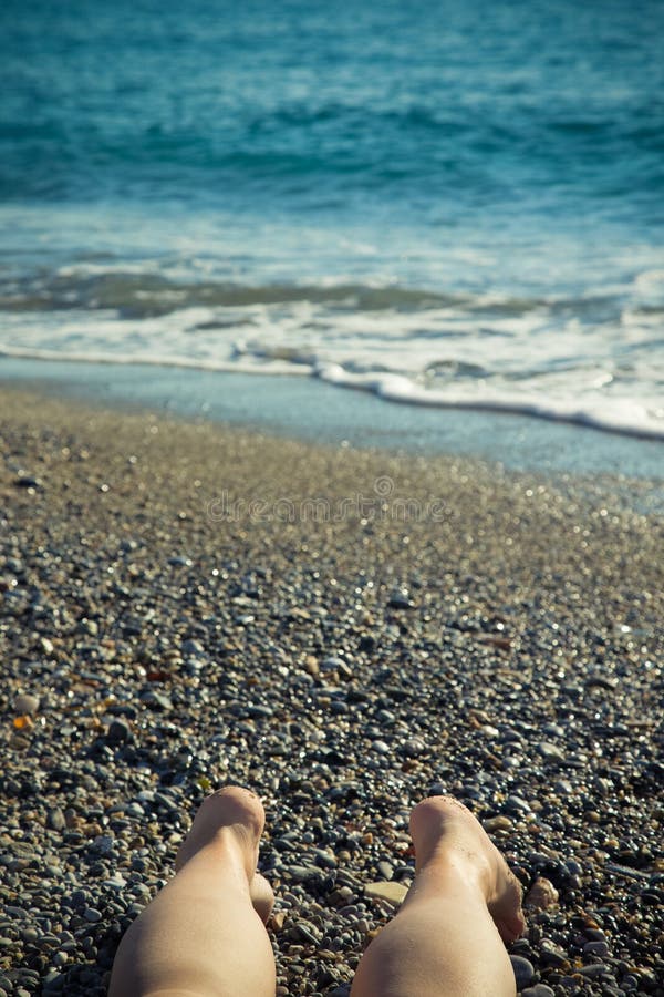 Female Legs on the Pebble Coast of Sea. Selective Focus Stock Image ...