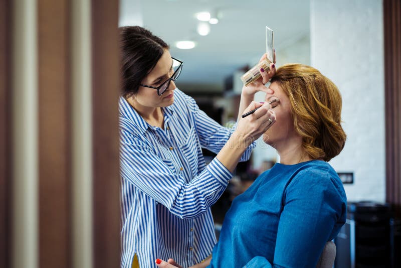 Female Make Up Artist Working on Model in Salon Stock Photo - Image of ...
