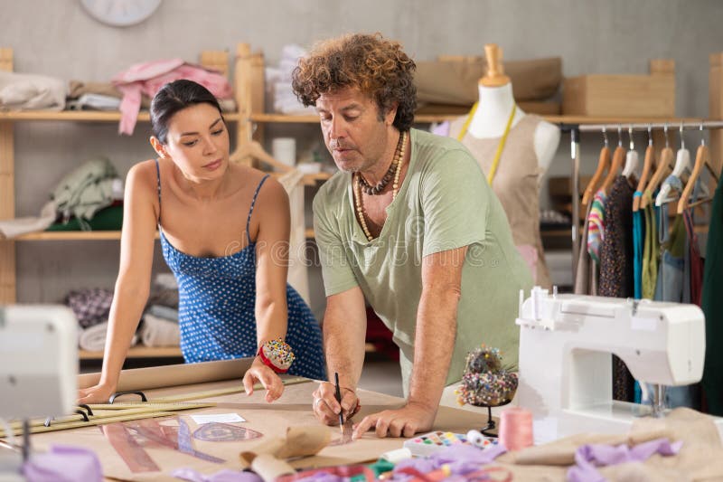 Female and Male Dressmakers Drawing on Paper in Sewing Studio Stock ...