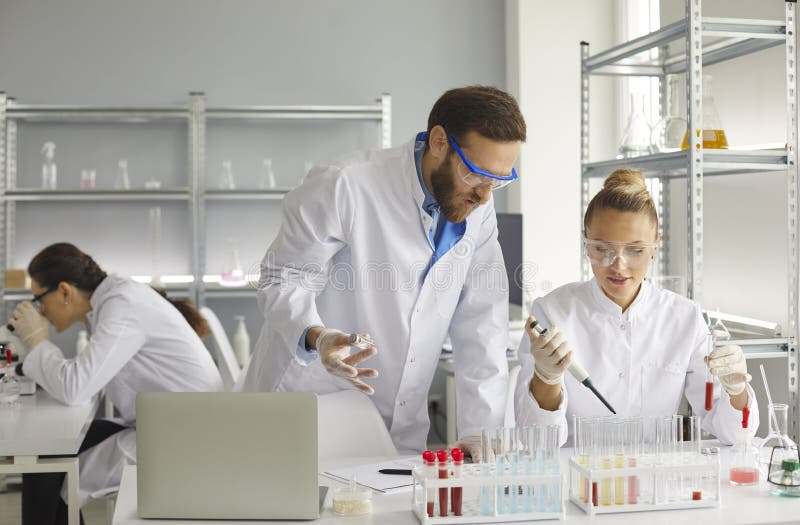 Female and Male Scientists Work Together To Analyze Samples while ... Female and Male Scientists Work Together To Analyze Samples while ...
