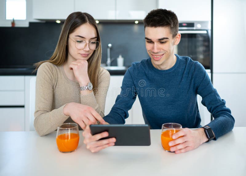 Female and Male Students Using Tablet Together and Drinking Juice at ...