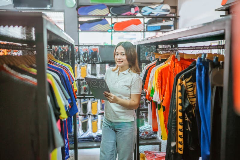 Female Manager Checking Hanging Sportswear Using Tablet Stock Photo ...