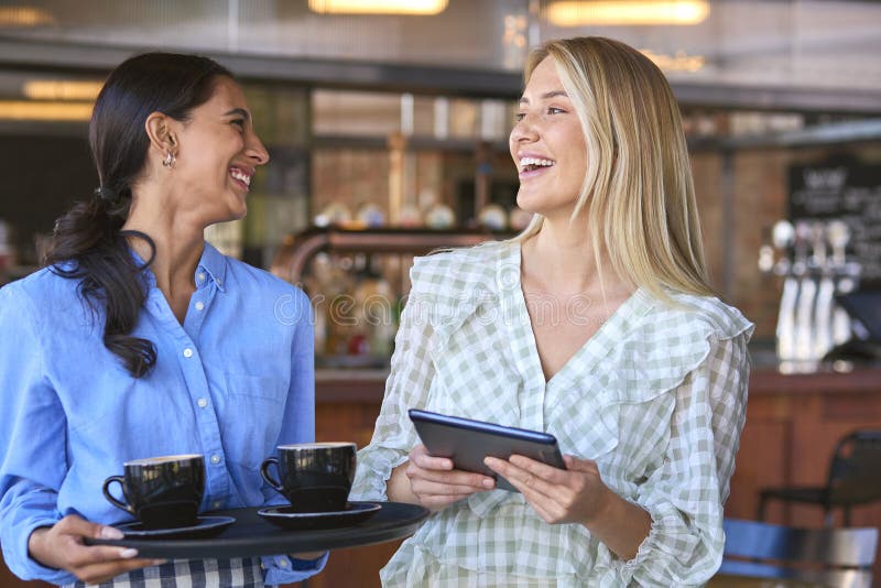Female Manager with Digital Tablet and Waitress Working in Restaurant ...