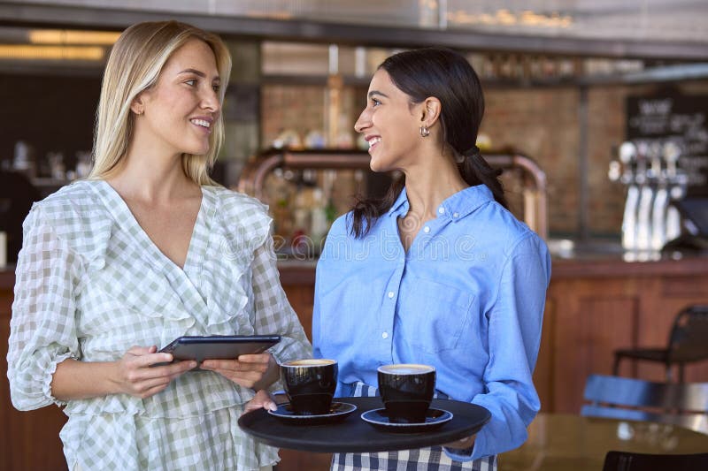 Female Manager with Digital Tablet and Waitress Working in Restaurant ...
