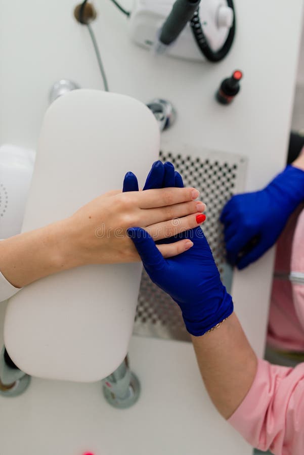 Female Manicure Master in a Beauty Salon Work with Hands of the Client ...