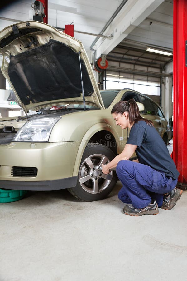Female Mechanic Changing Wheel Stock Image - Image of remove, repair ...