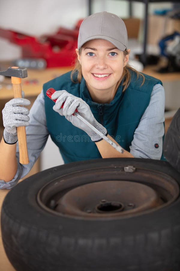 Female Mechanic Using Hammer and Chisel on Tyre Stock Photo - Image of ...