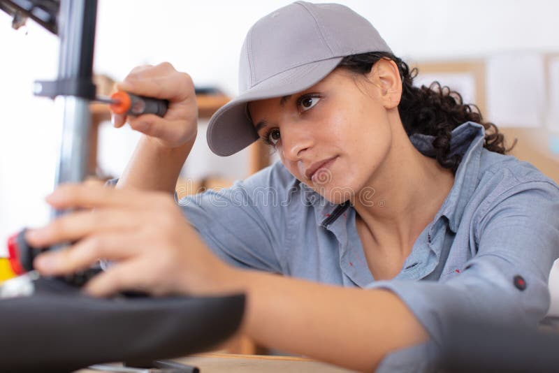 Female Mechanic Using Screwdriver To Adjust Bicycle Seat Stock Photo ...