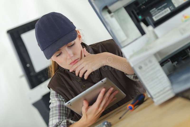 Female Mechanic Using Tablet To Fix Printer Stock Photo - Image of ...