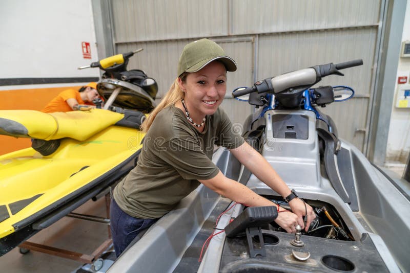 Female Mechanic Repairing Personal Watercraft Engine in Workshop Stock ...