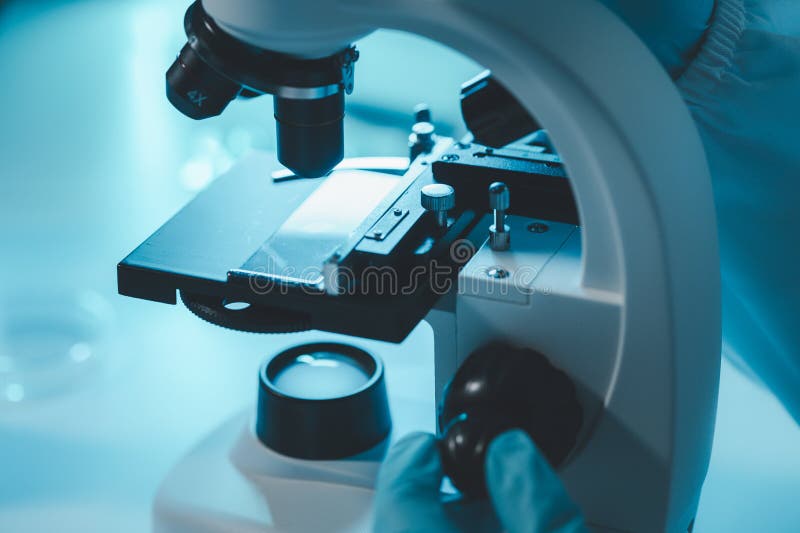 Female Medic in Uniform Working with Microscope Making Analysis at the ...