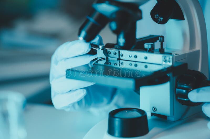 Female Medic in Uniform Working with Microscope Making Analysis at the ...