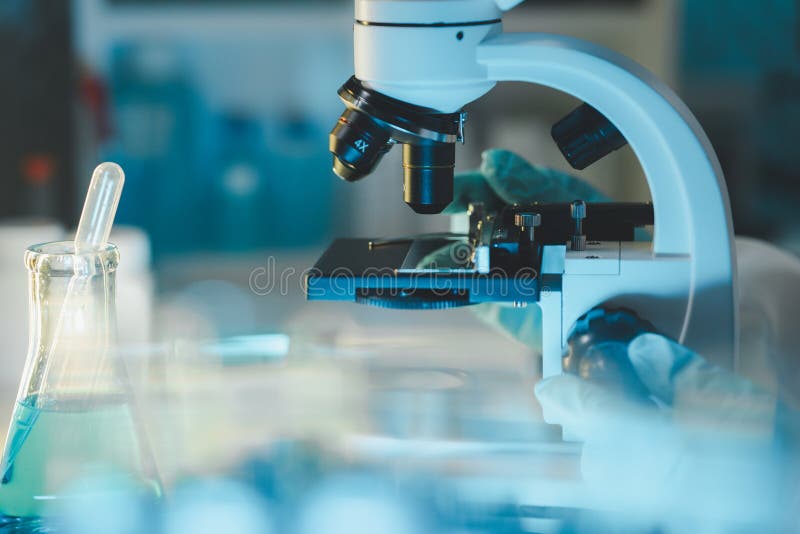 Female Medic in Uniform Working with Microscope Making Analysis at the ...