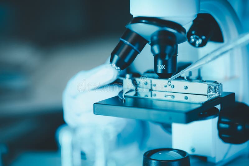 Female Medic in Uniform Working with Microscope Making Analysis at the ...