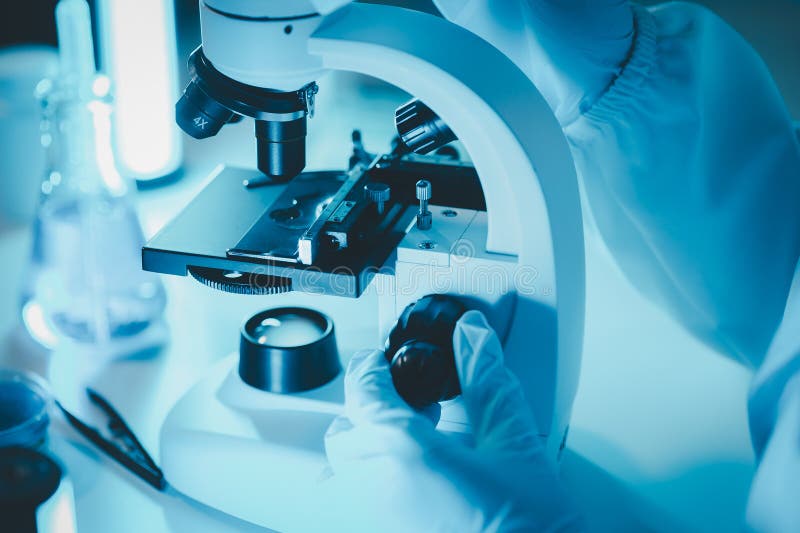 Female Medic in Uniform Working with Microscope Making Analysis at the ...