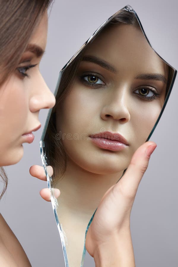 Female with Mirror Shard in Hand Posing on Gray Background. Face ...