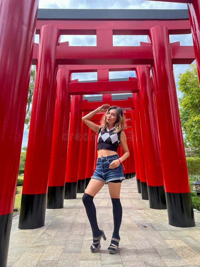 Female Model Poses Under a Red Bridge Prop in a Park. Stock Image ...