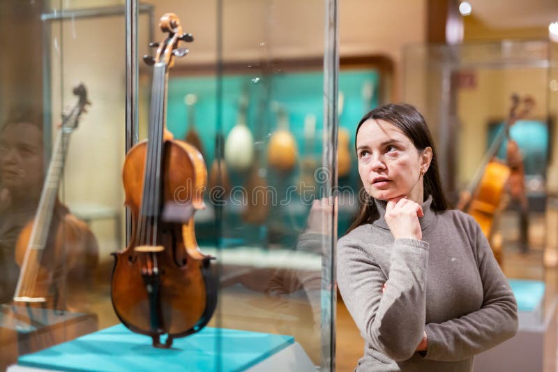 Female Museum Visitor Examining Ancient Musical Instruments Stock Image ...
