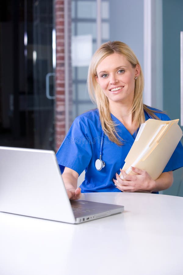 Female nurse at a desk stock photo. Image of document - 8593842
