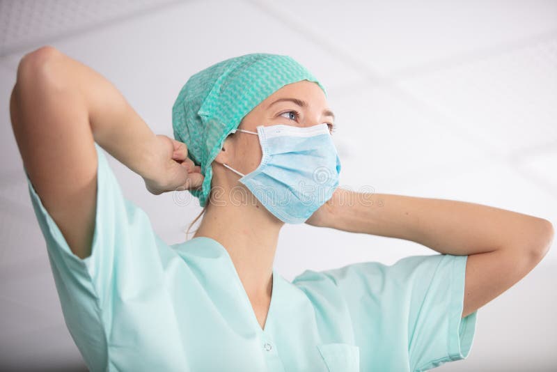 Female Nurse Putting on Mask Stock Photo - Image of mask, professional ...